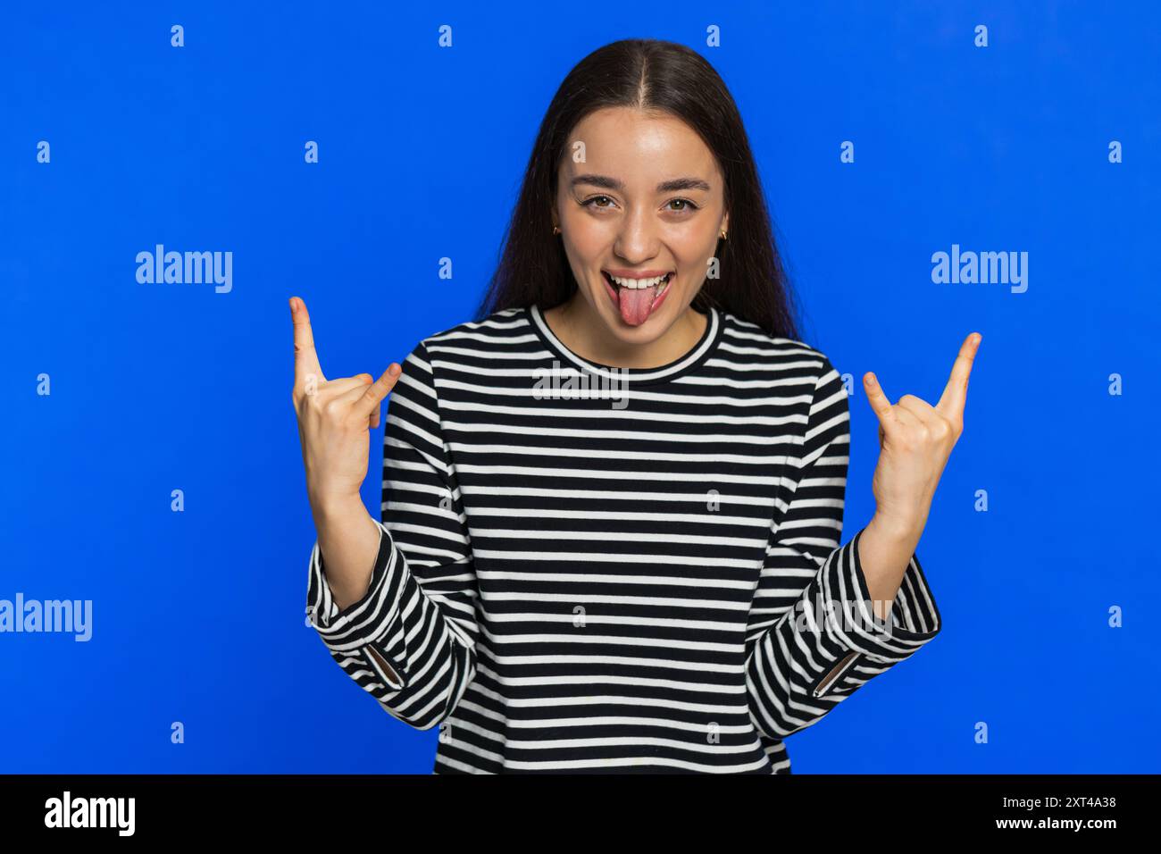 Overjoyed happy Caucasian girl woman in striped blouse showing rock n ...