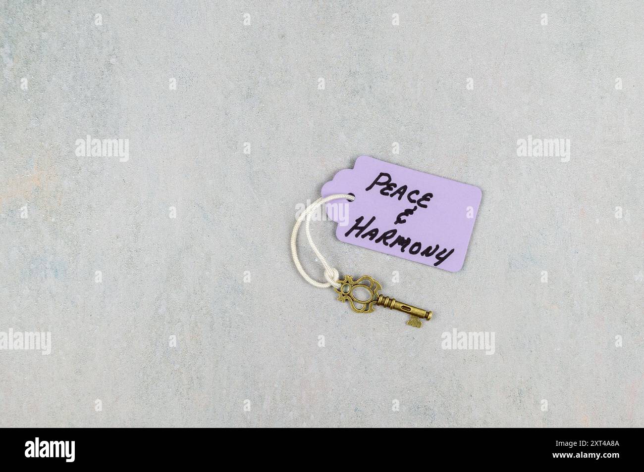 Small key with tag - concept: Key to peace and harmony Stock Photo - Alamy