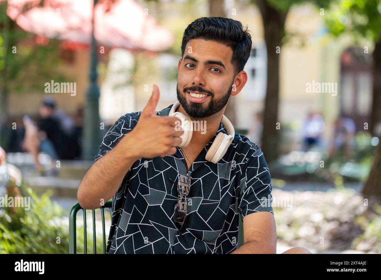 Like. Happy young Indian man tourist looking approvingly at camera showing thumbs up sign ...