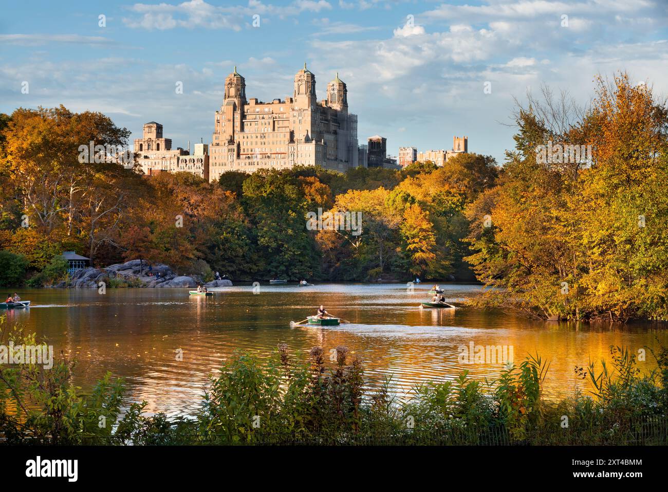 New York City Central Park Lake in autumn with people rowing boats and ...
