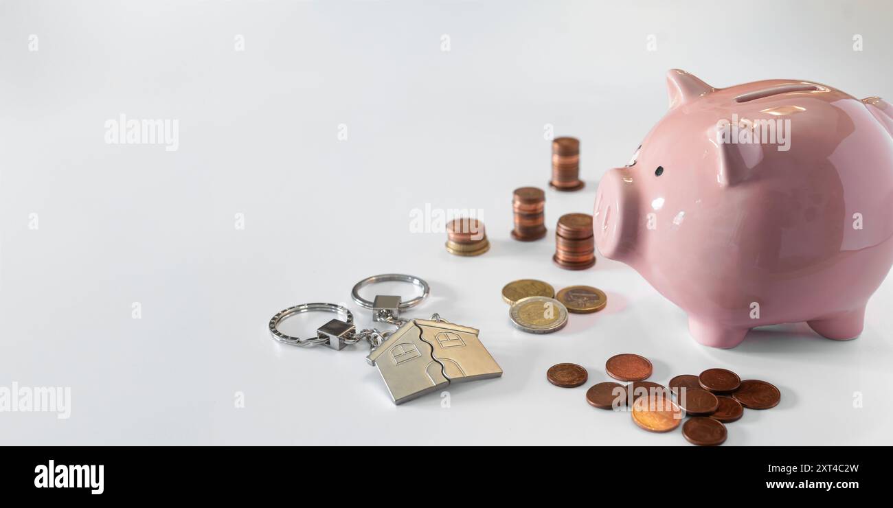 A piggy bank, coin and a house key ring on a white background, savings ...
