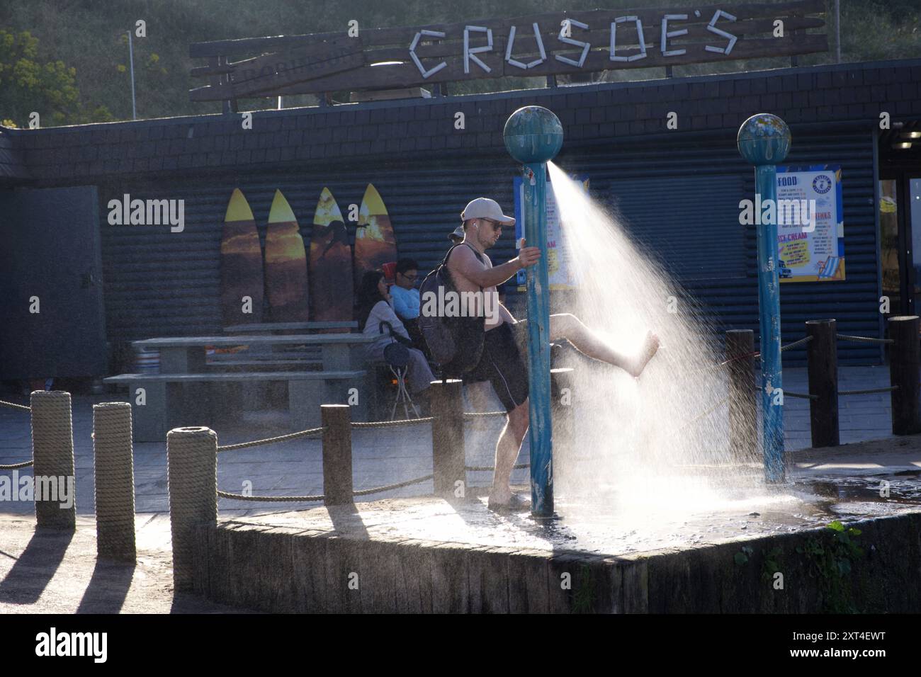 Man washing sand off his feet in a spray of water - summer on Tynemouth ...