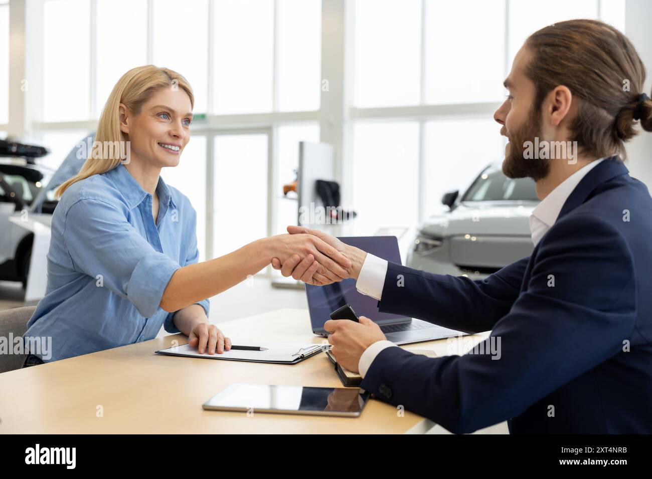 Rich woman customer client signing contract with salesman in car ...