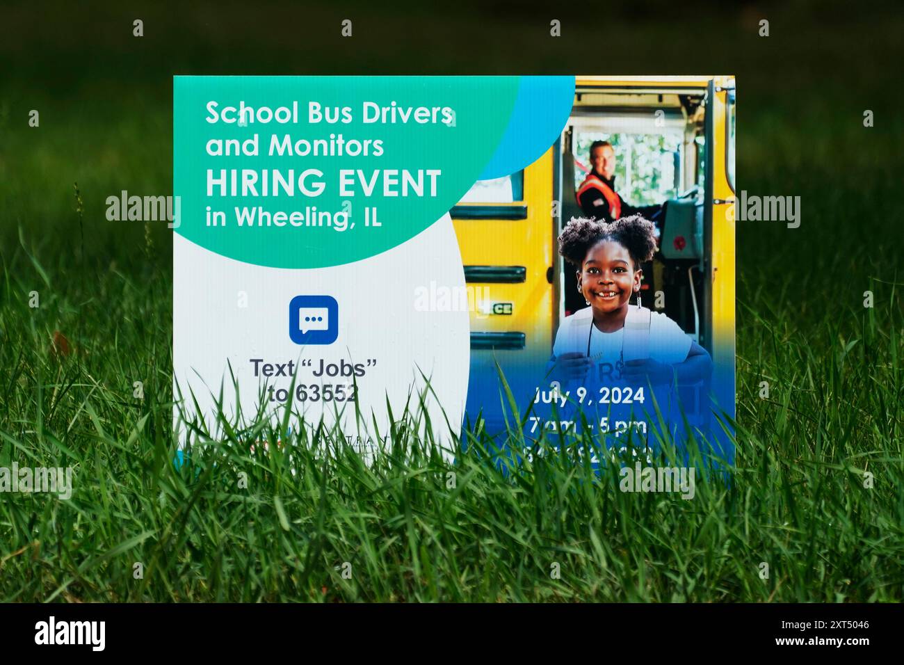 A hiring sign is displayed outside of a school bus service building in ...