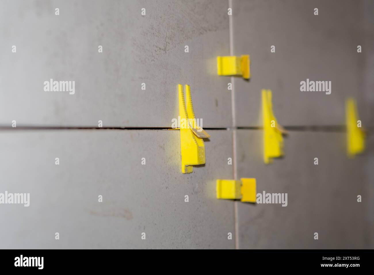 Detailed view of tile leveling system in use with plastic clips and ...