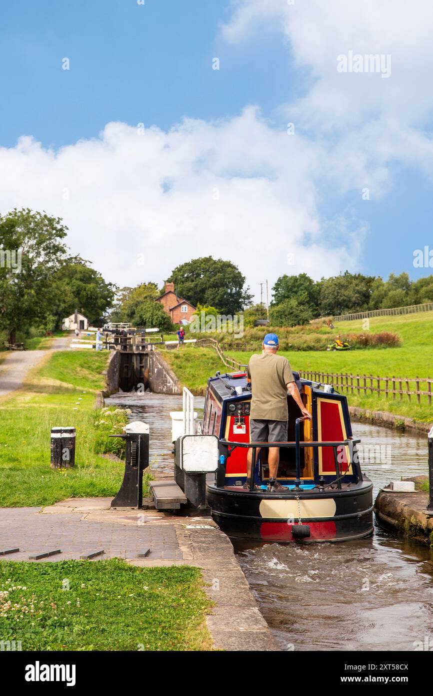 People on a canal narrowboat passing through Hurleston locks on the ...