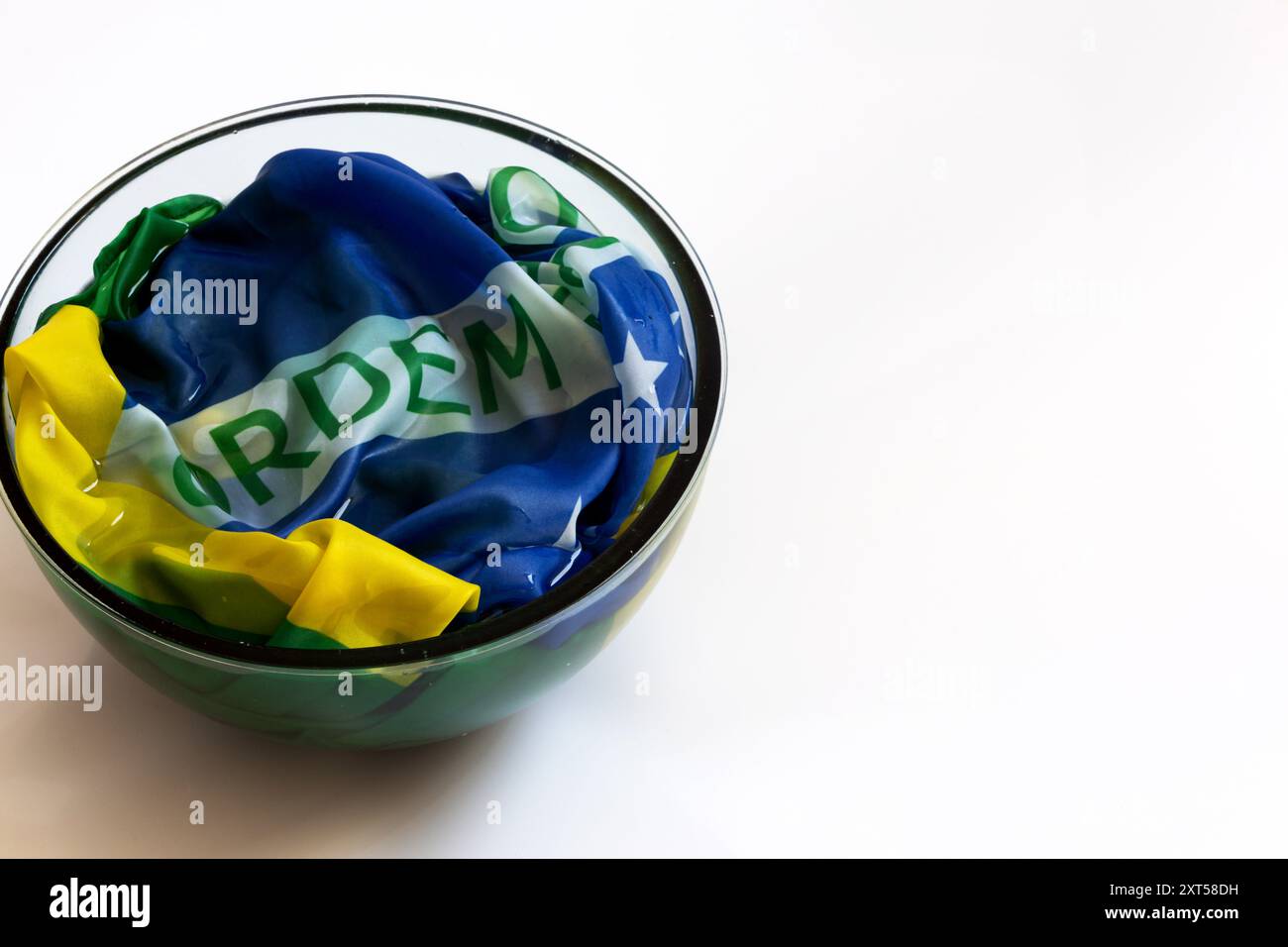 Brazilian flag soaking in water inside a glass container with the word ...