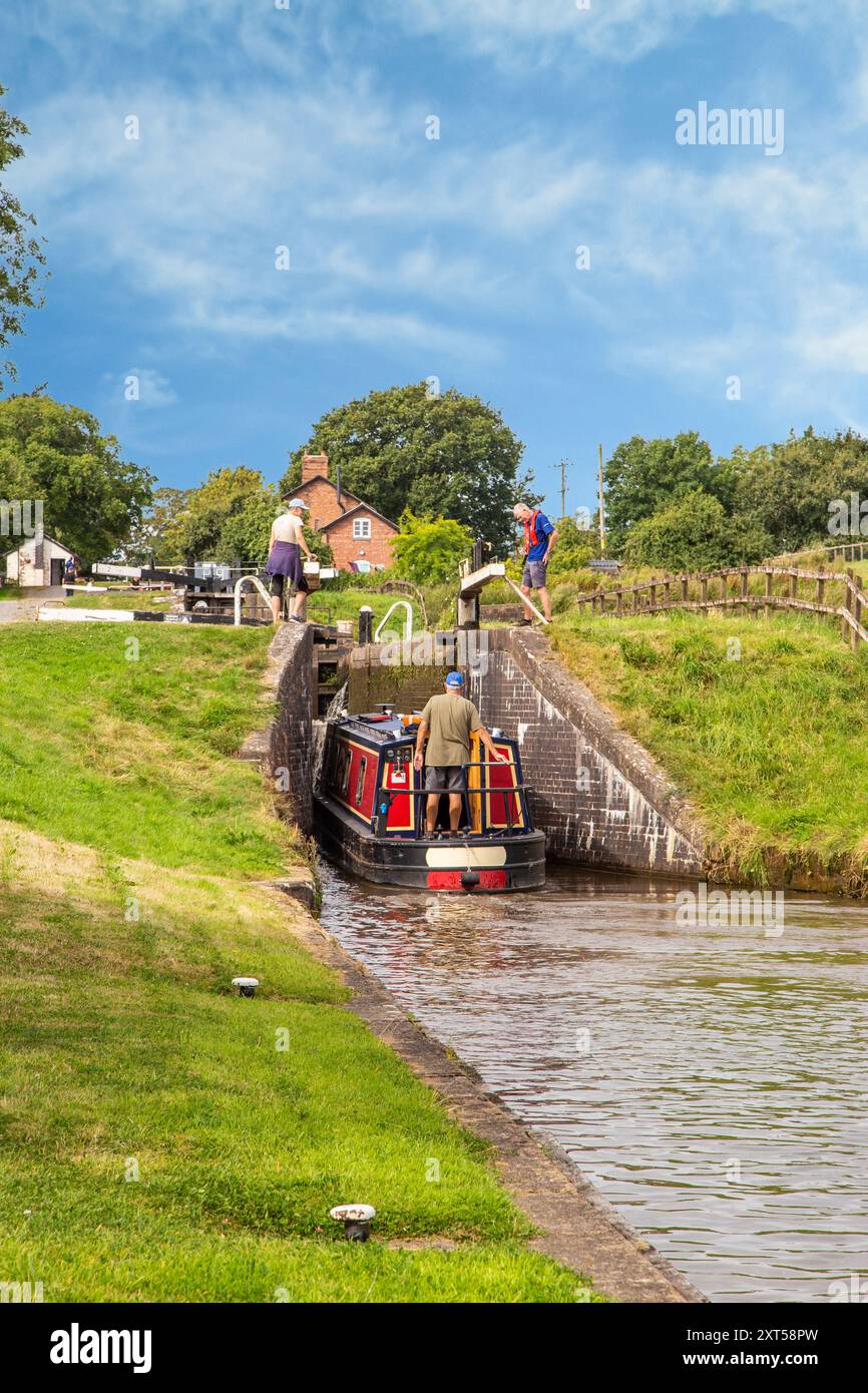 People on a canal narrowboat passing through Hurleston locks on the ...