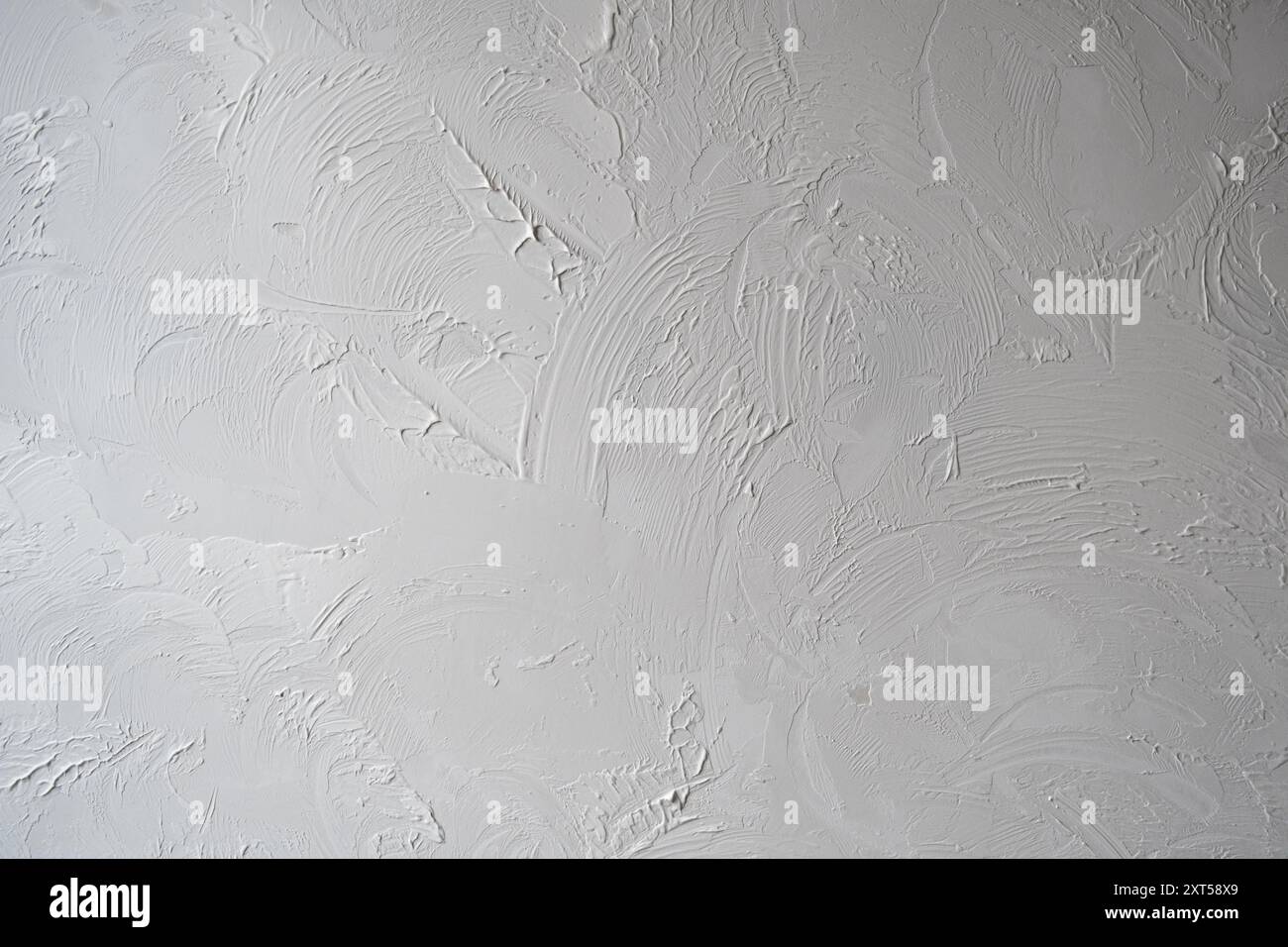 Applying decorative putty. White abstract texture of surface covered ...