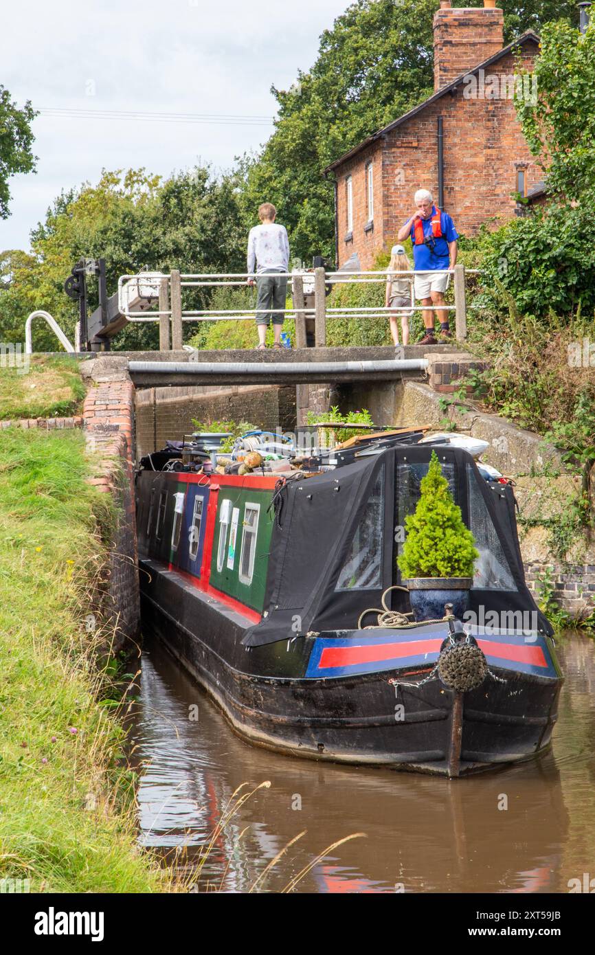 People on canal narrowboats, passing through Hurleston top locks on the ...