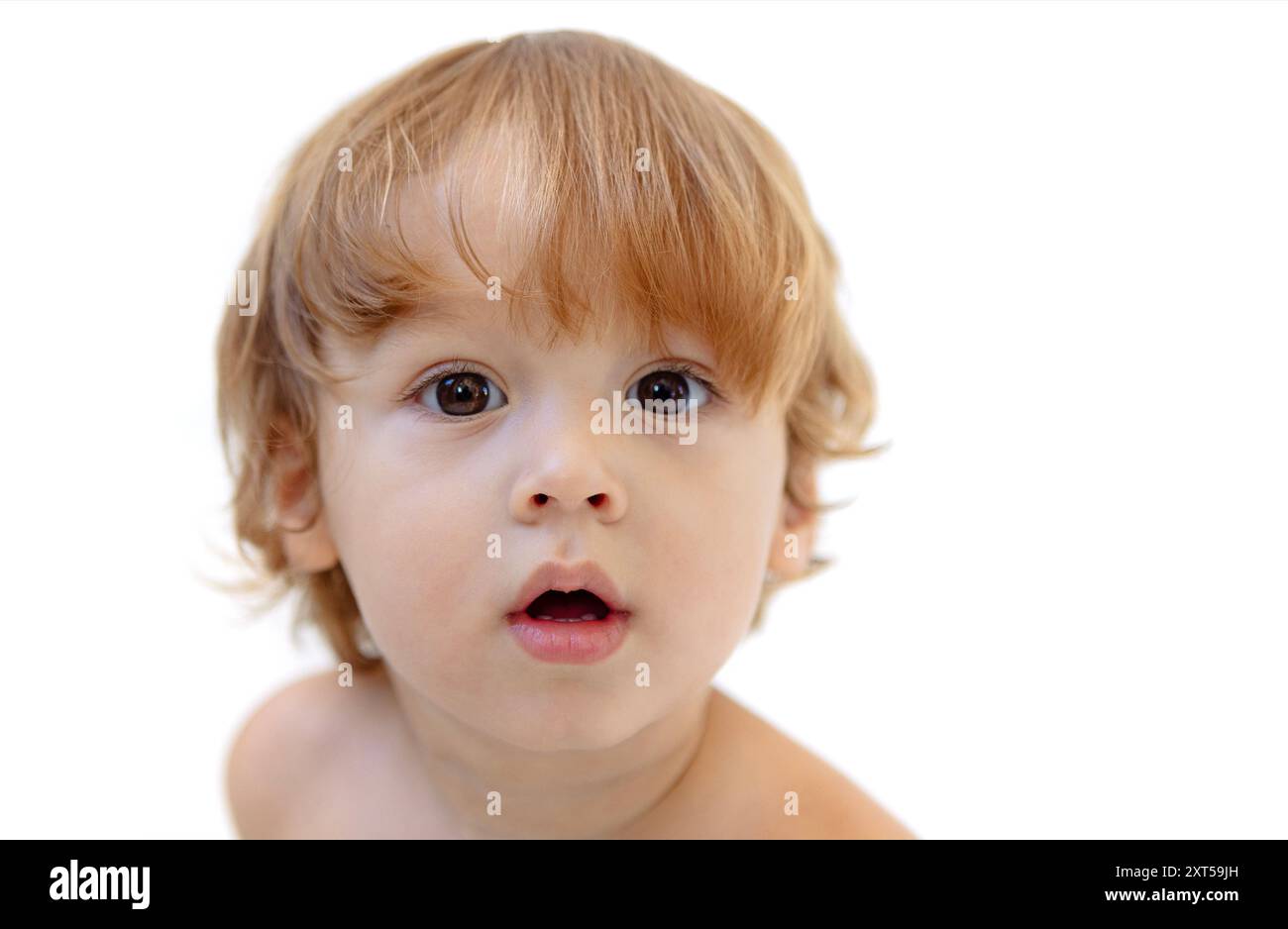A close-up portrait of a surprised cute baby. A blond sweet little boy ...
