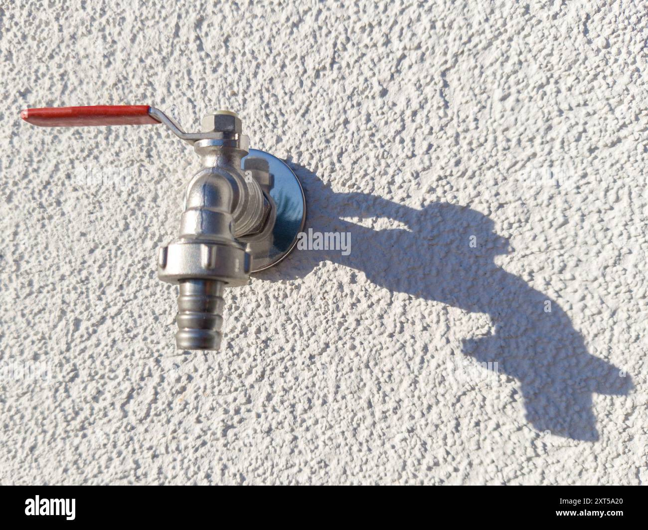 Outdoor Water Faucet with Red Handle Casting Shadow Stock Photo - Alamy