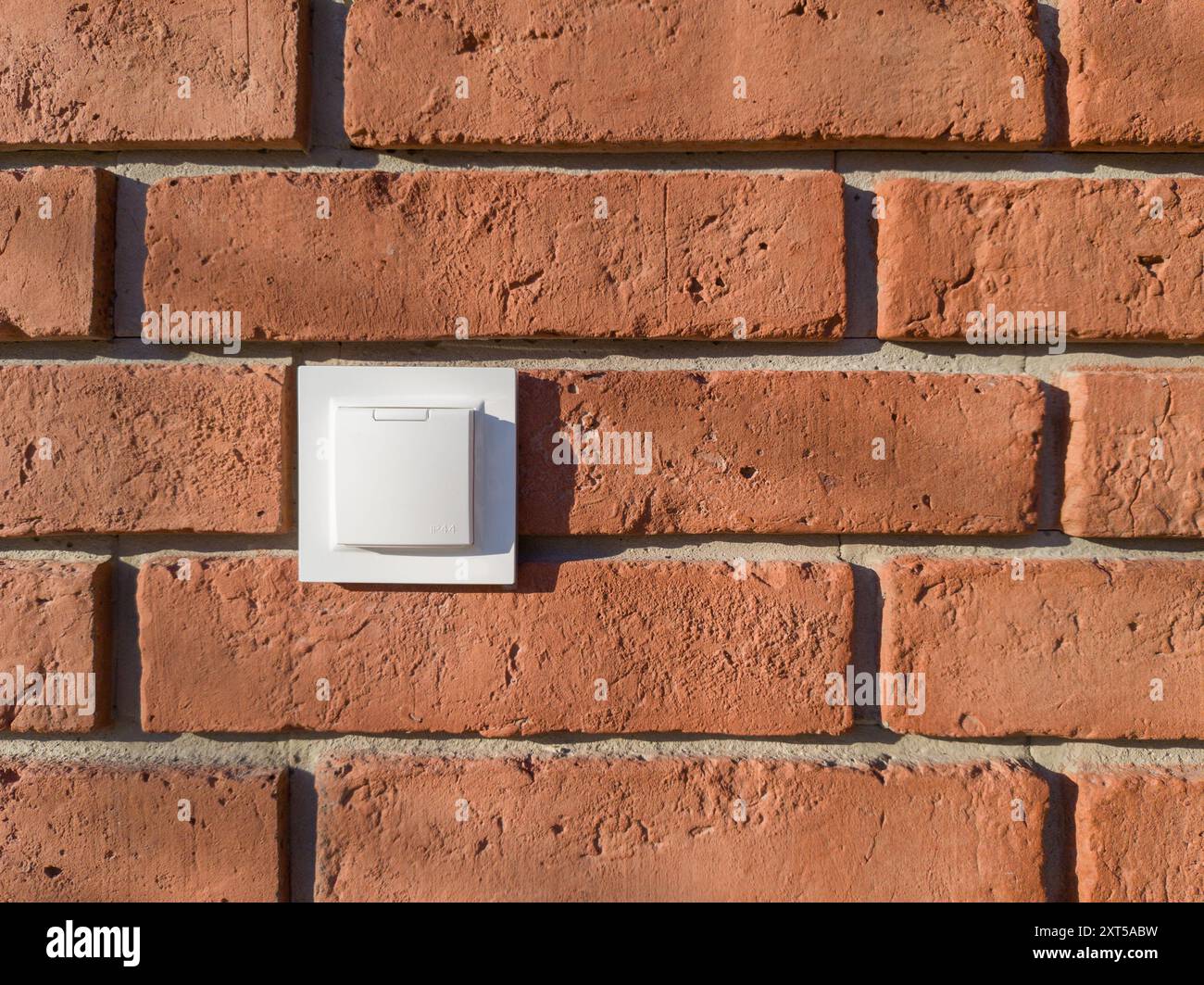 White Electrical Outlet on Red Brick Wall Stock Photo - Alamy