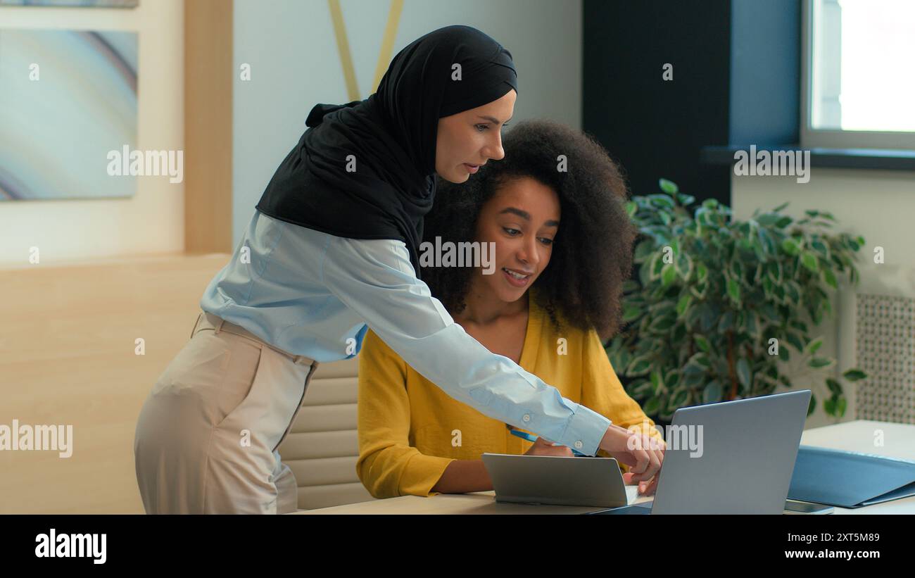 Arabian muslim islamic businesswoman in hijab mentoring new employee ...