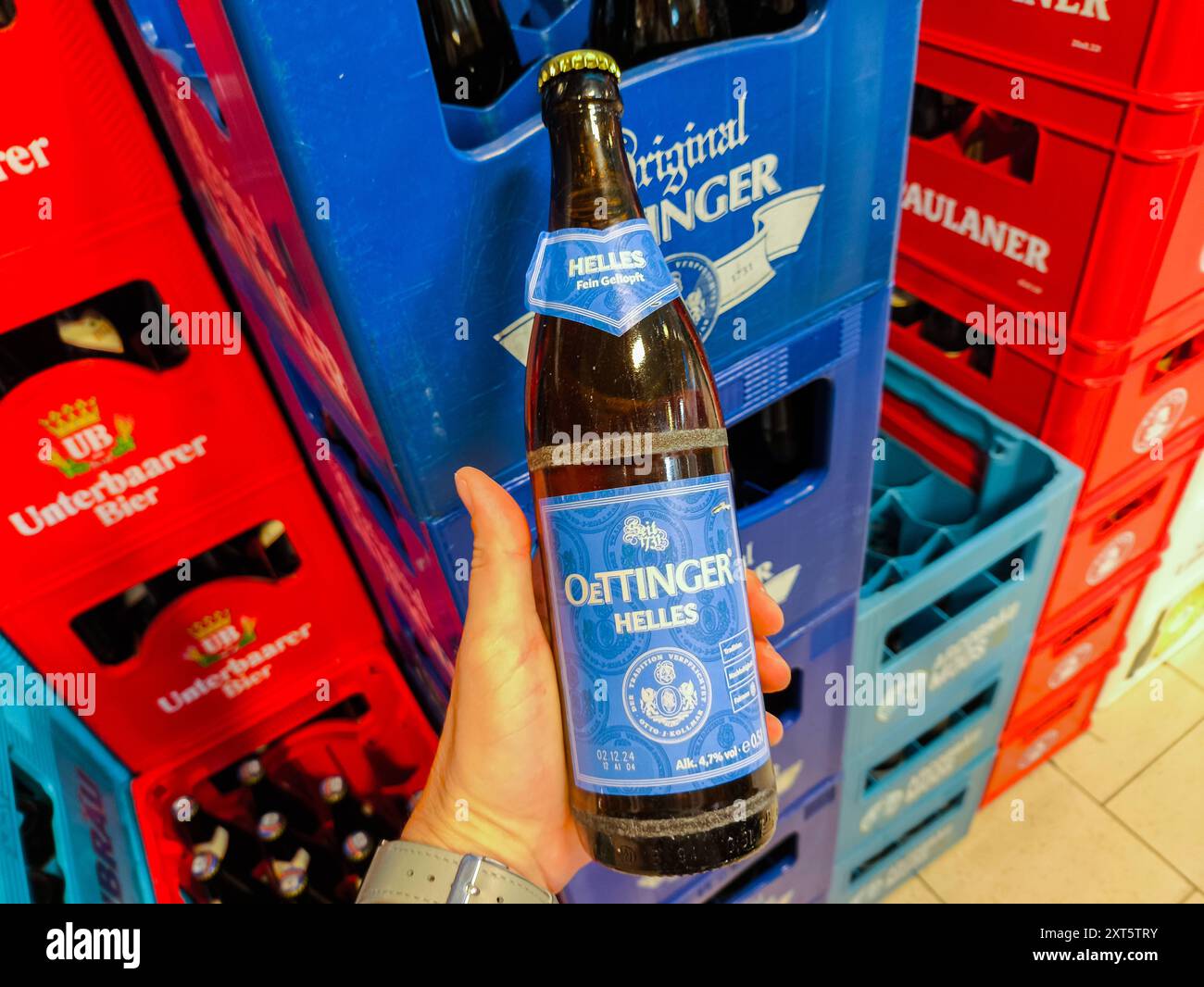 Bavaria, Germany - August 12, 2024: Hand holding a bottle of Oettinger ...