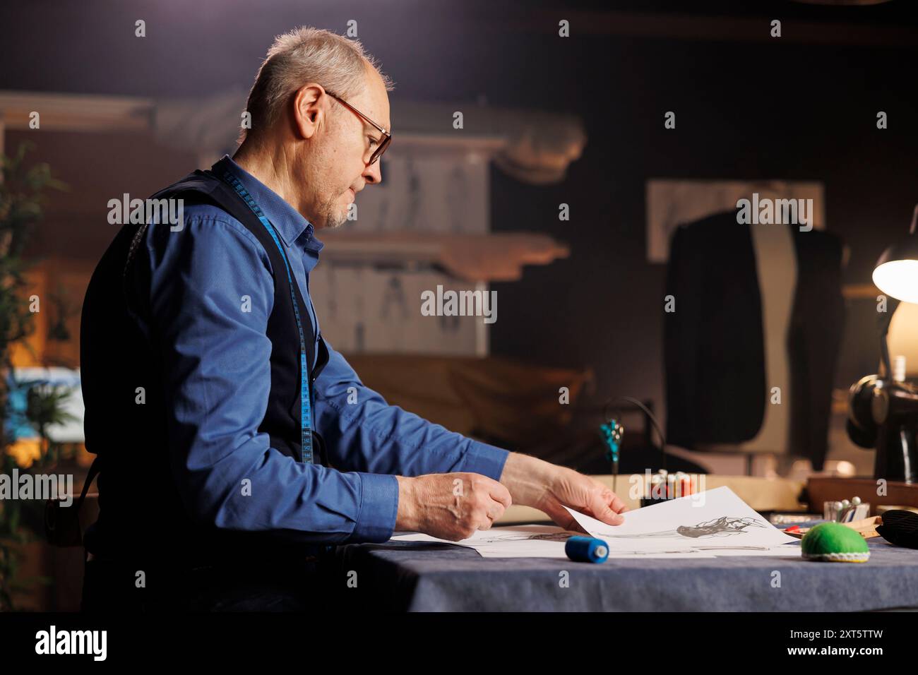 Experienced senior couturier creating outfits for upcoming fashion ...