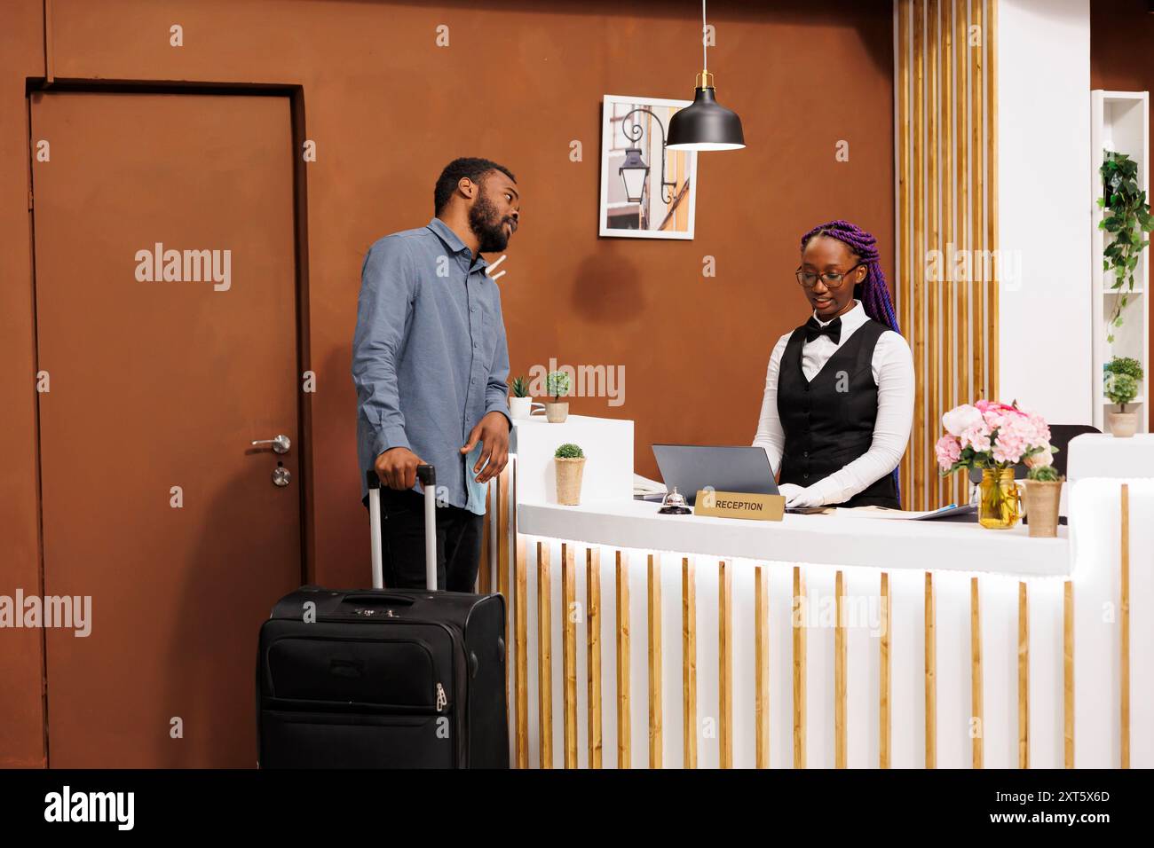 Friendly African American woman receptionist using laptop computer ...