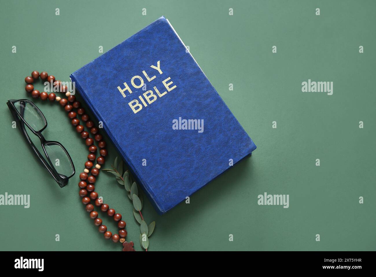 Holy Bible with eyeglasses and prayer beads on green background Stock ...