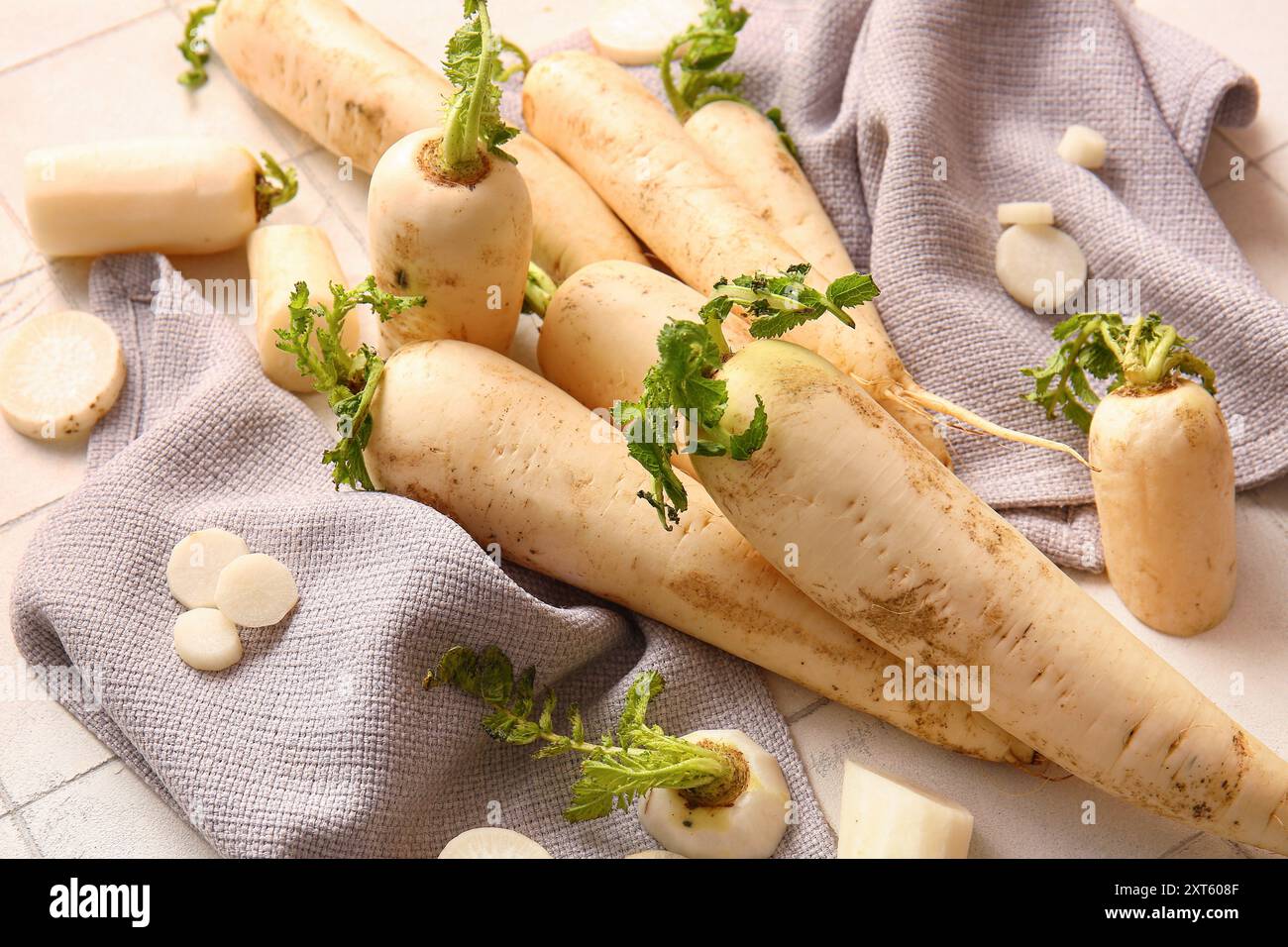 Fresh daikon radishes on white tile background Stock Photo - Alamy