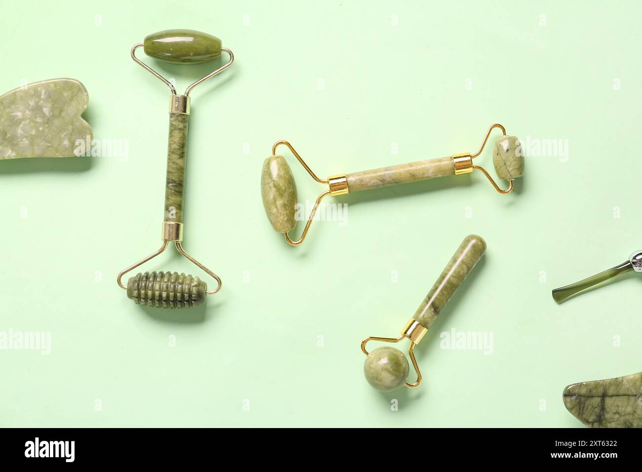 Different facial massage tools on green background Stock Photo - Alamy