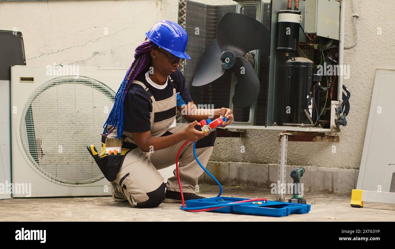 African american repairman unpacking toolbox with manifold gauges ...