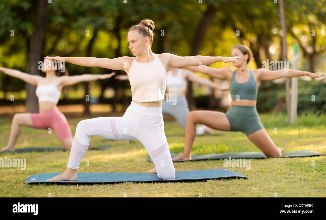 Group yoga classes in summer park - girls in different yoga poses Stock ...