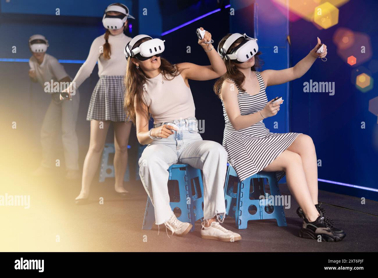 Female friends playing pair versus pair virtual reality game Stock ...