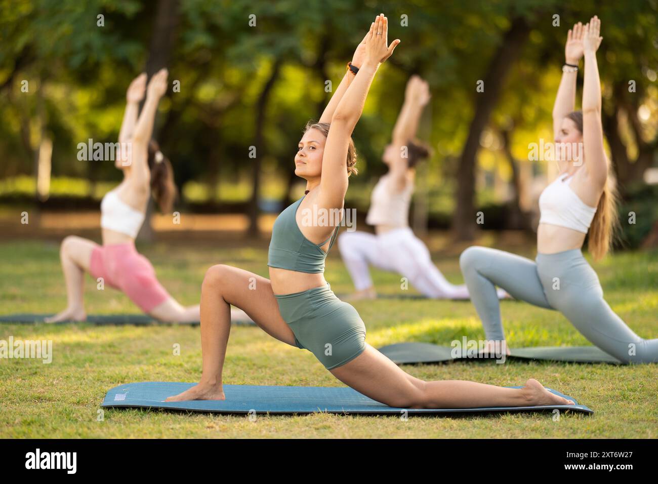 Group yoga classes in summer park - girls in different yoga poses Stock ...