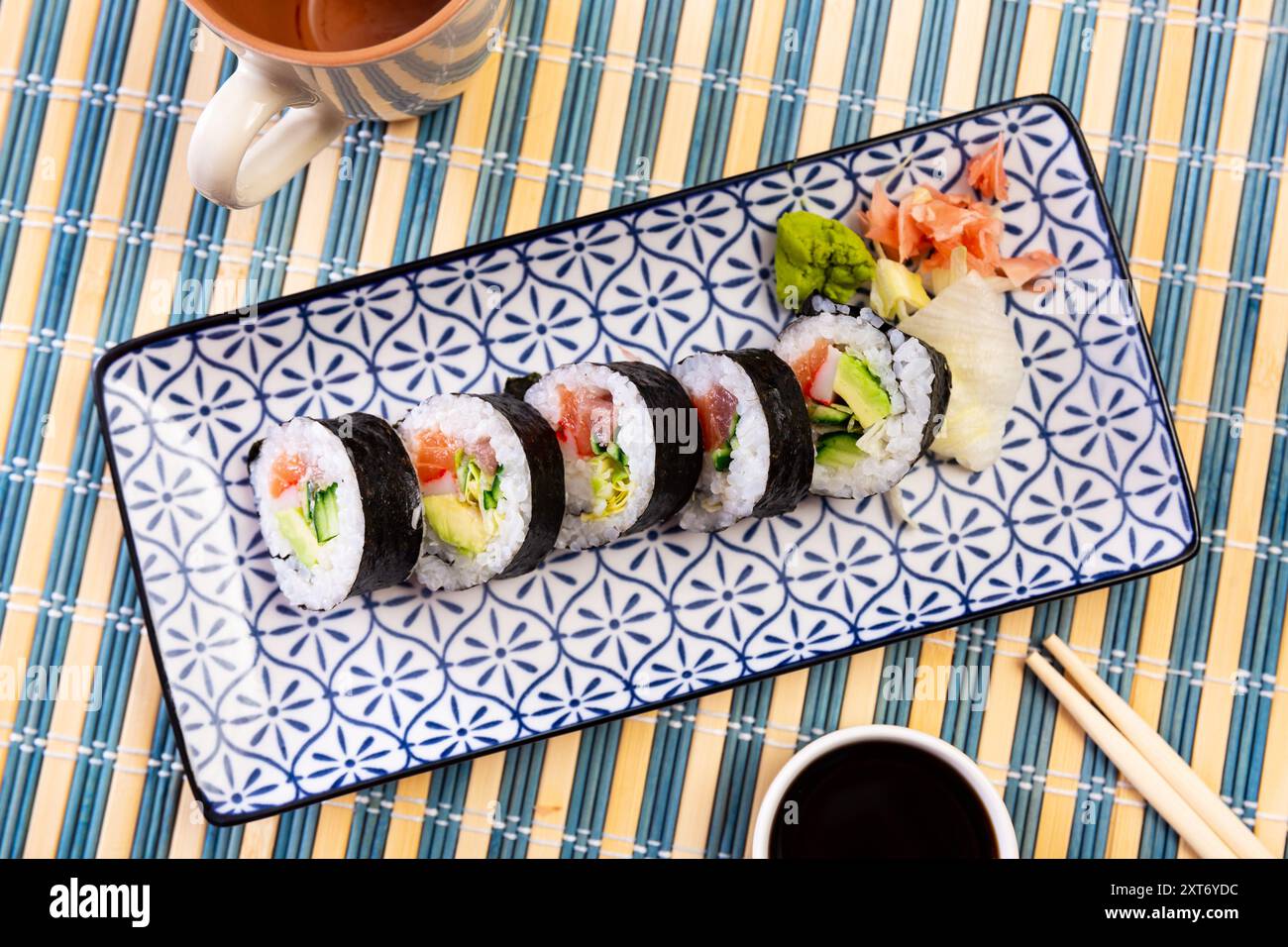 Sushi roll futomaki with cucumber, avocado, tuna, surimi, salad and ...