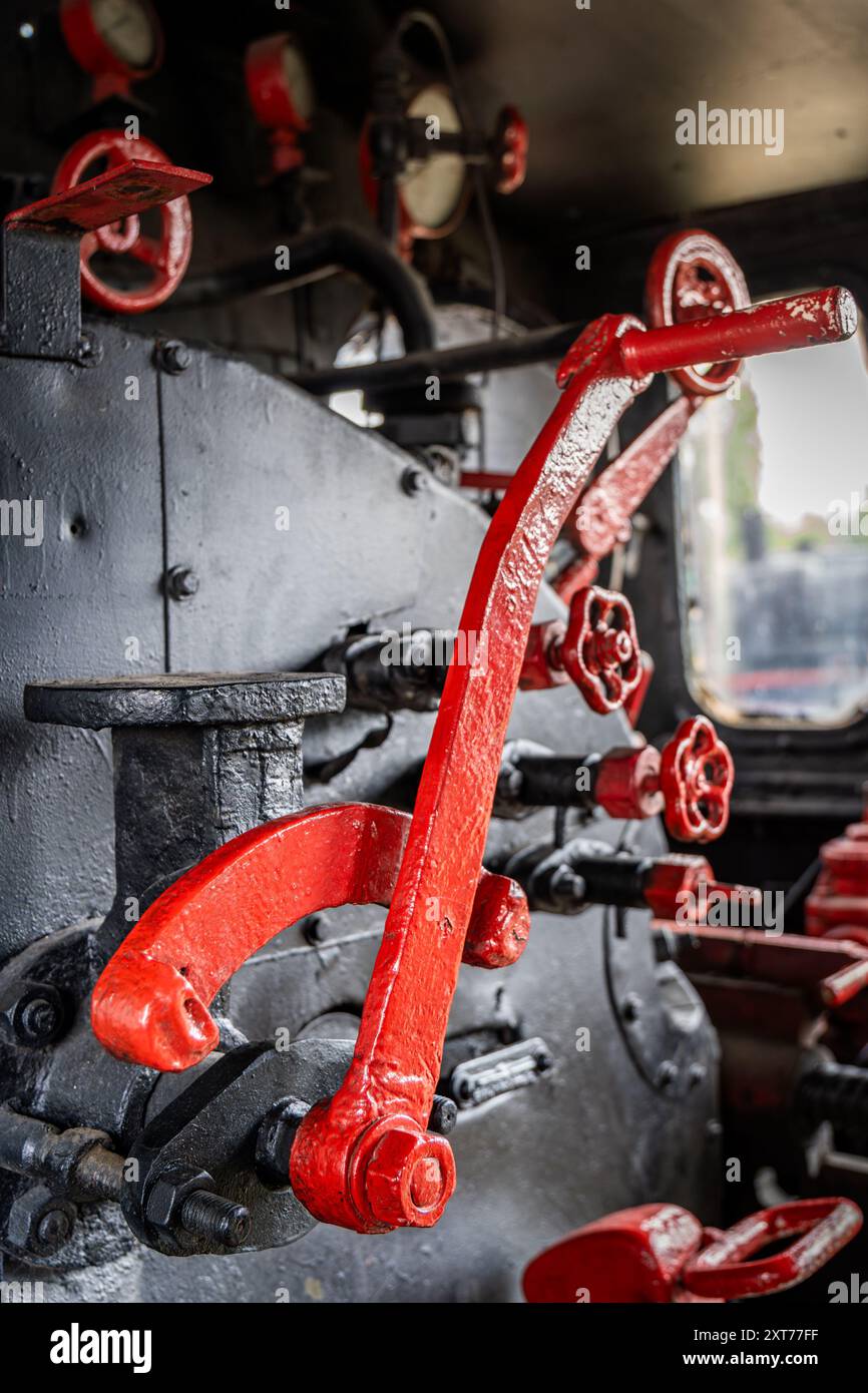 Close-up of red valves and control mechanisms inside a steam locomotive ...