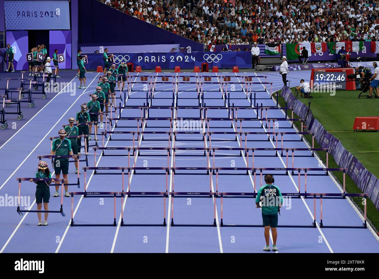Volounteers prepare hurdles before the women's 100m hurdles during the ...