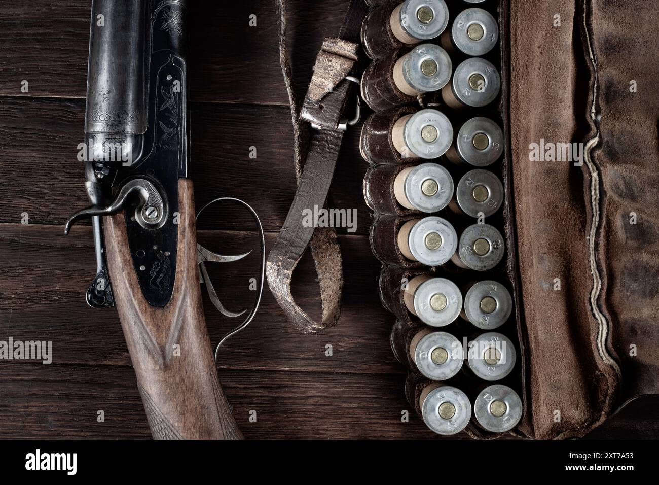 double barreled side shotgun with cartridges in bandolier on wooden ...