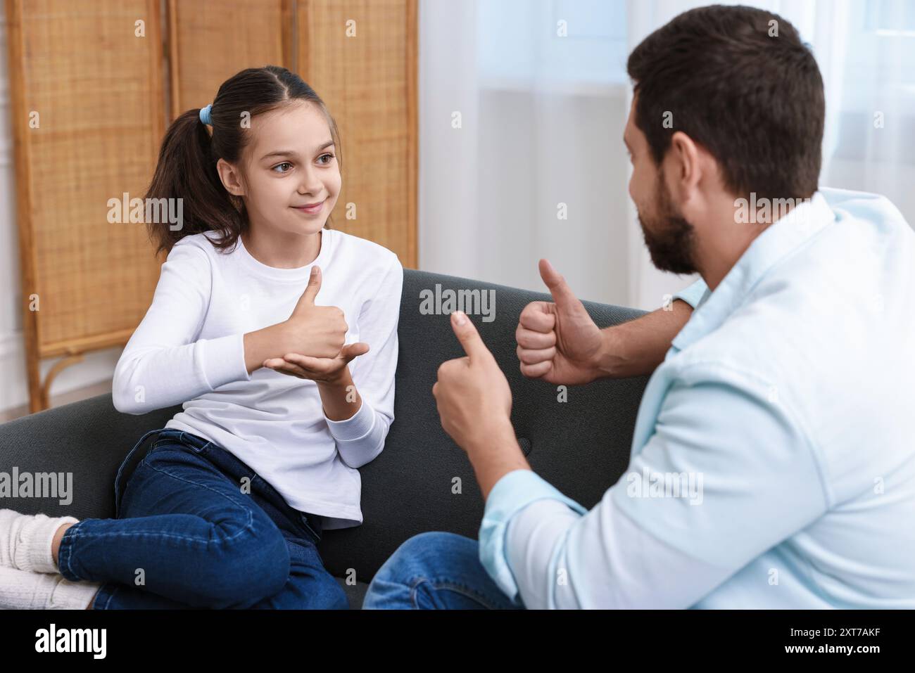 Man and his daughter using sign language for communication at home ...