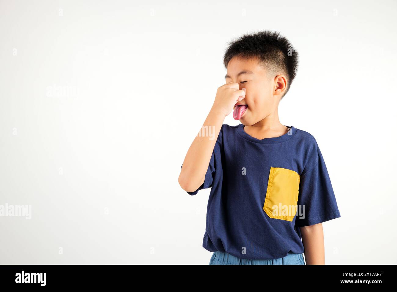 Asian young child unhappy what a smell disgust expression squeezing ...