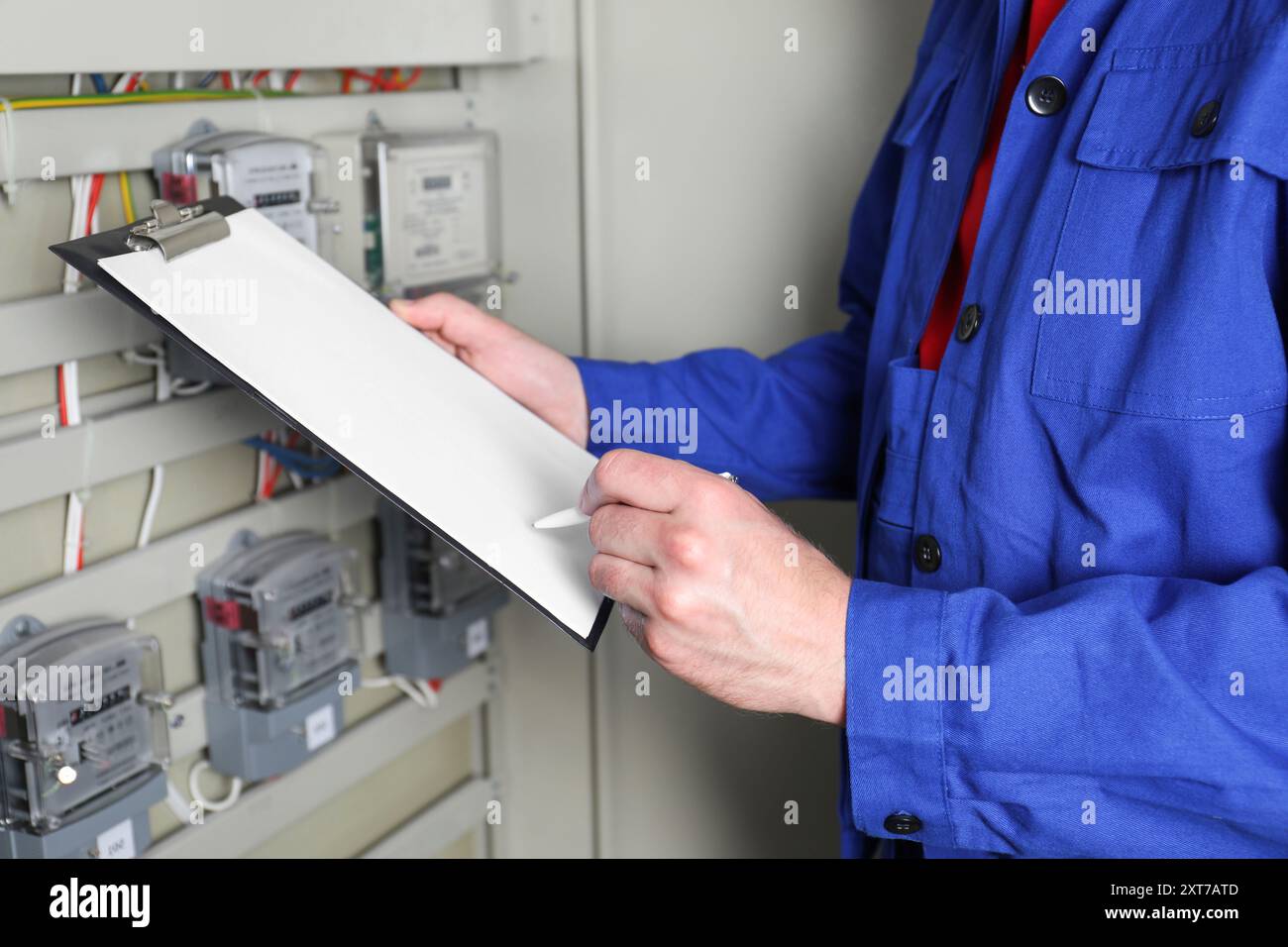 Technician worker with clipboard inspecting electricity meter, closeup ...