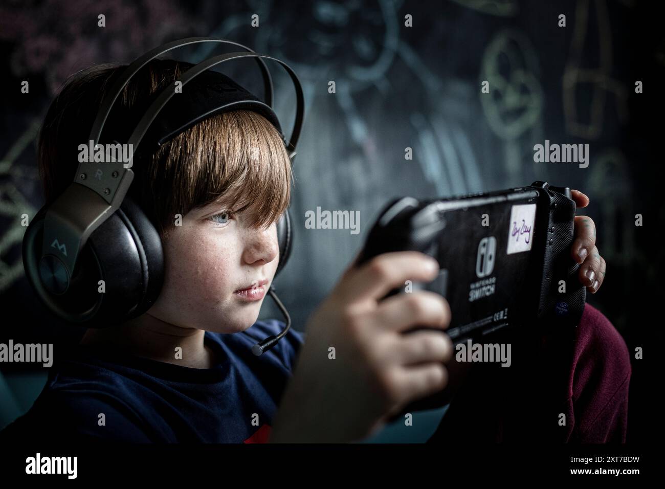 Boy playing on a portable gaming console Stock Photo - Alamy