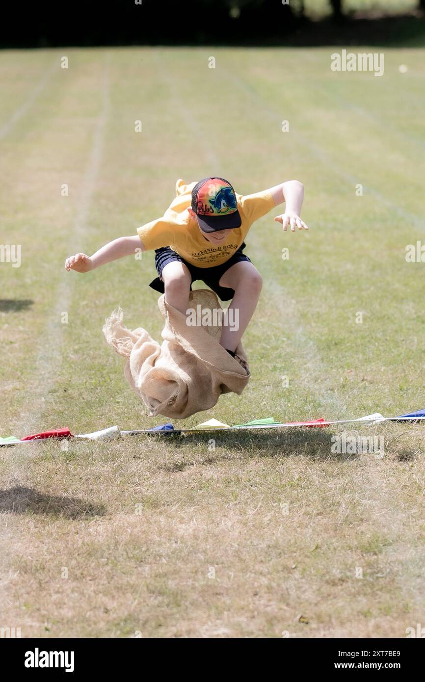 Boy icrossing the finishing line of a sack race Stock Photo - Alamy