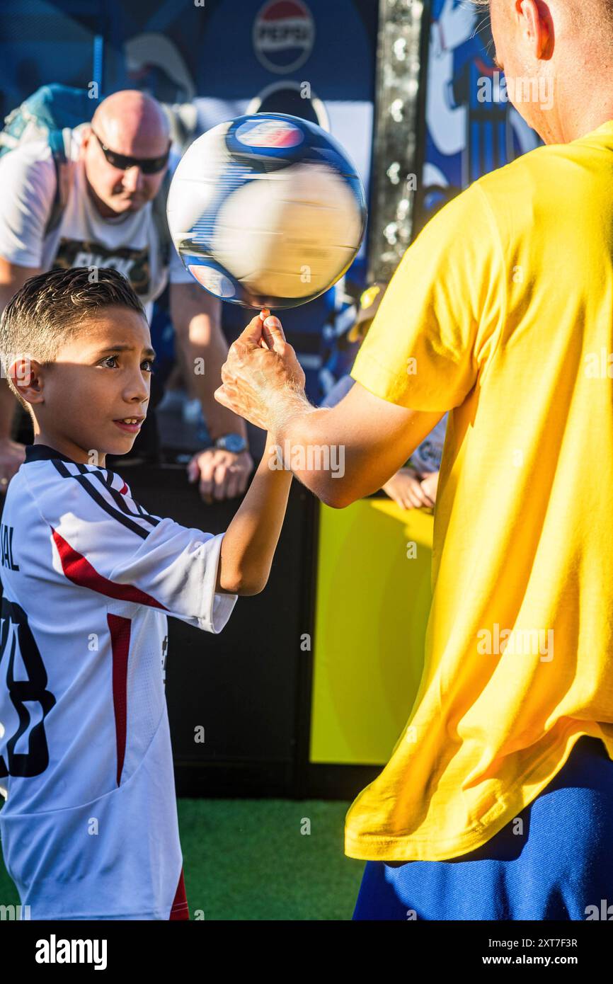A young fan is taught to spin the ball on his finger. Fans of Spanish ...