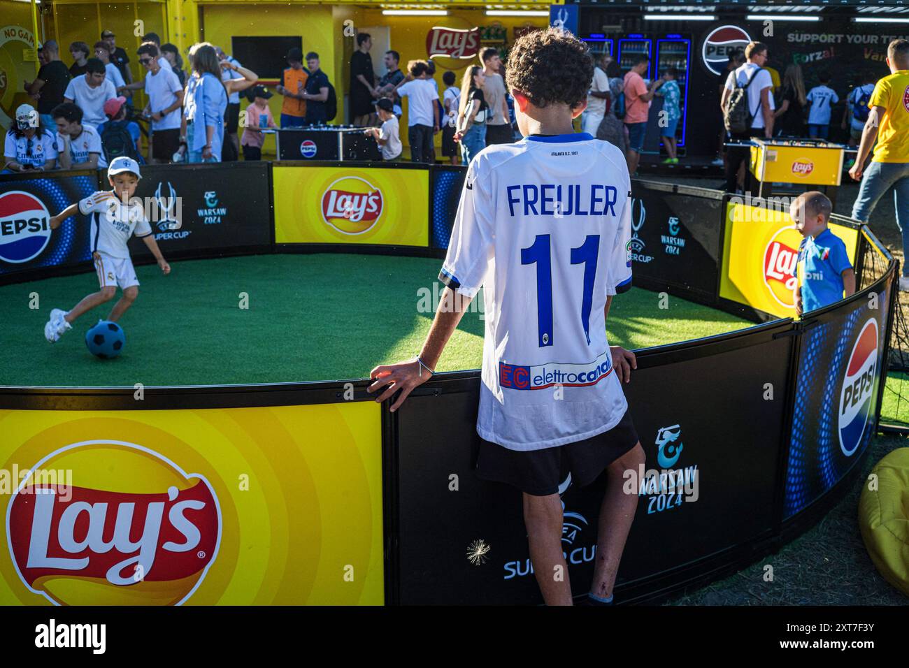Young football fans play 1vs1 football in the sunshine. Fans of Spanish ...