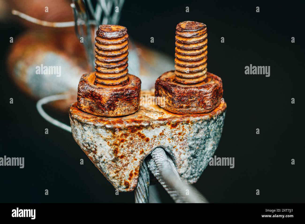 Rusty metal clamp holding steel cable tightly together, A symbol of ...