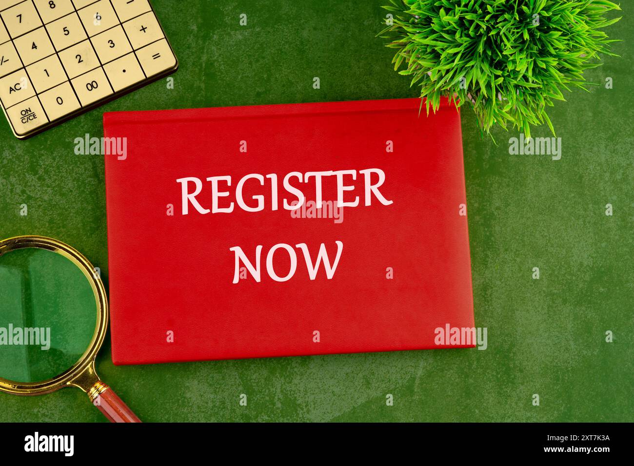 REGISTER NOW words written on the cover of a business book on a green ...
