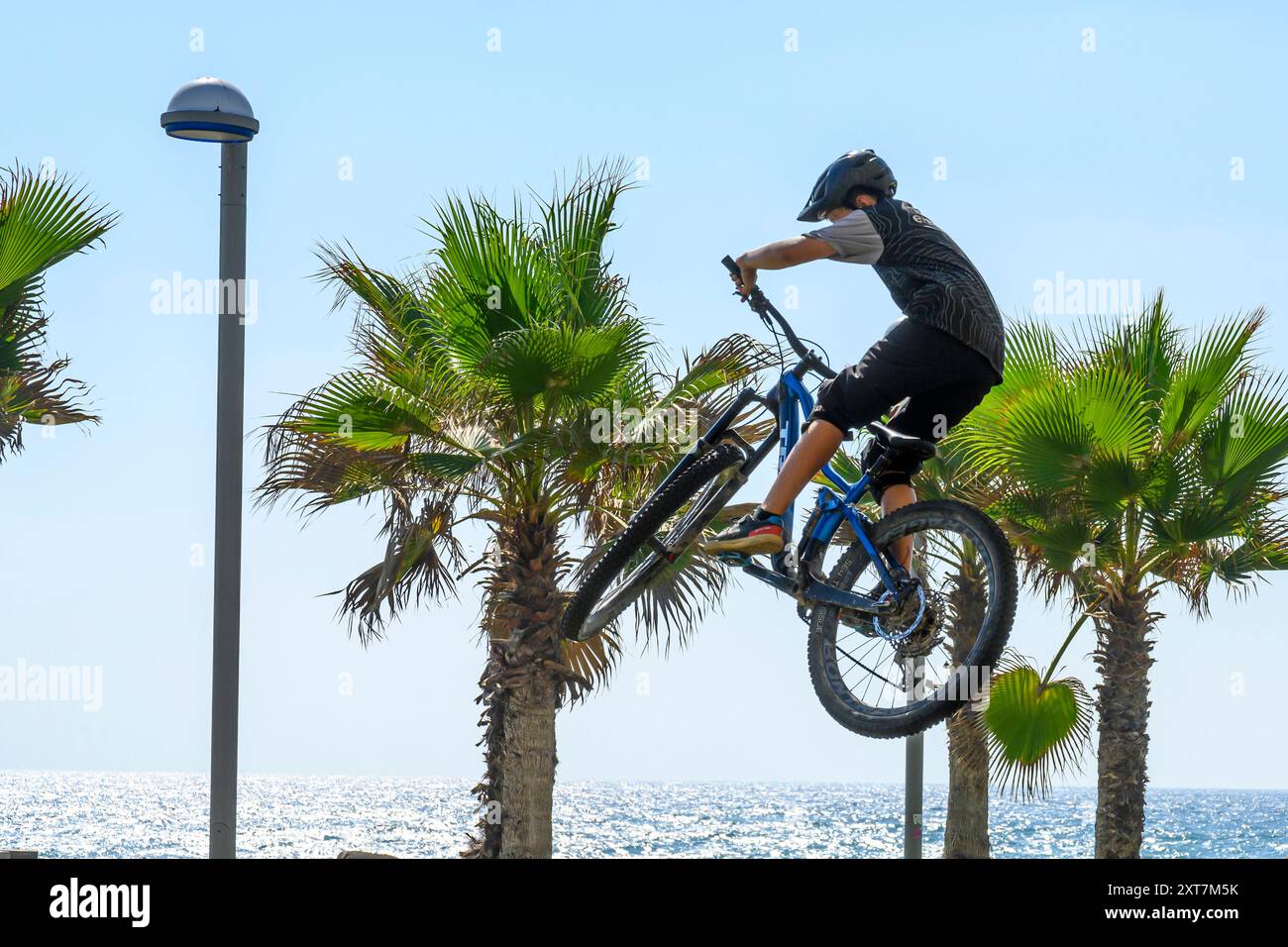 A boy performing a stunt with a bicycle at a skate park in Tel Aviv ...
