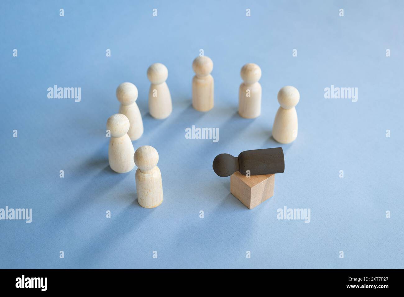 People figures or toy blocks with one lying down on podium. Failure or ...