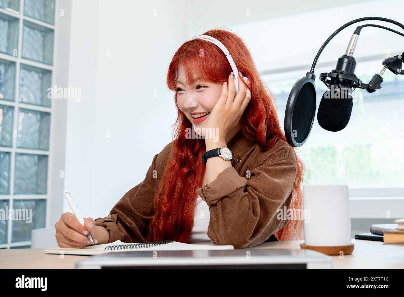 A charming and happy Asian female radio host or interviewer with red ...