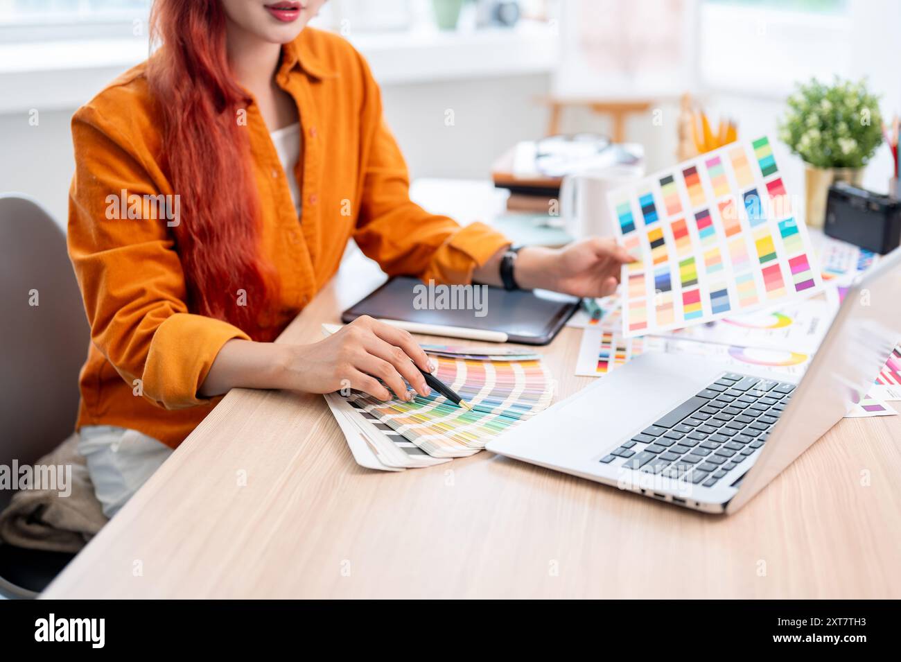 A cropped image of a creative female graphic designer is selecting ...