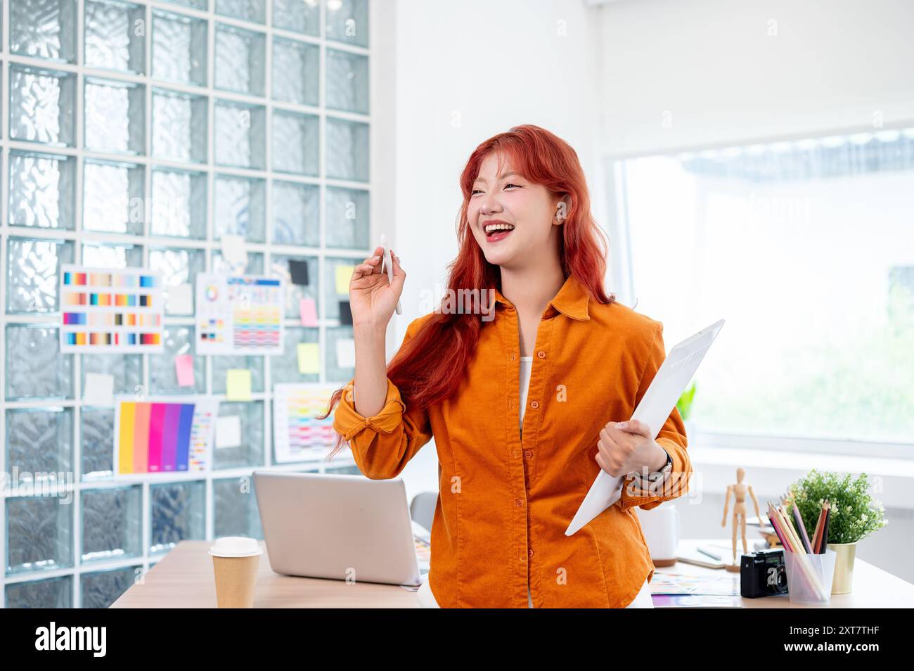 A portrait of a confident, cheerful Asian female graphic designer with ...