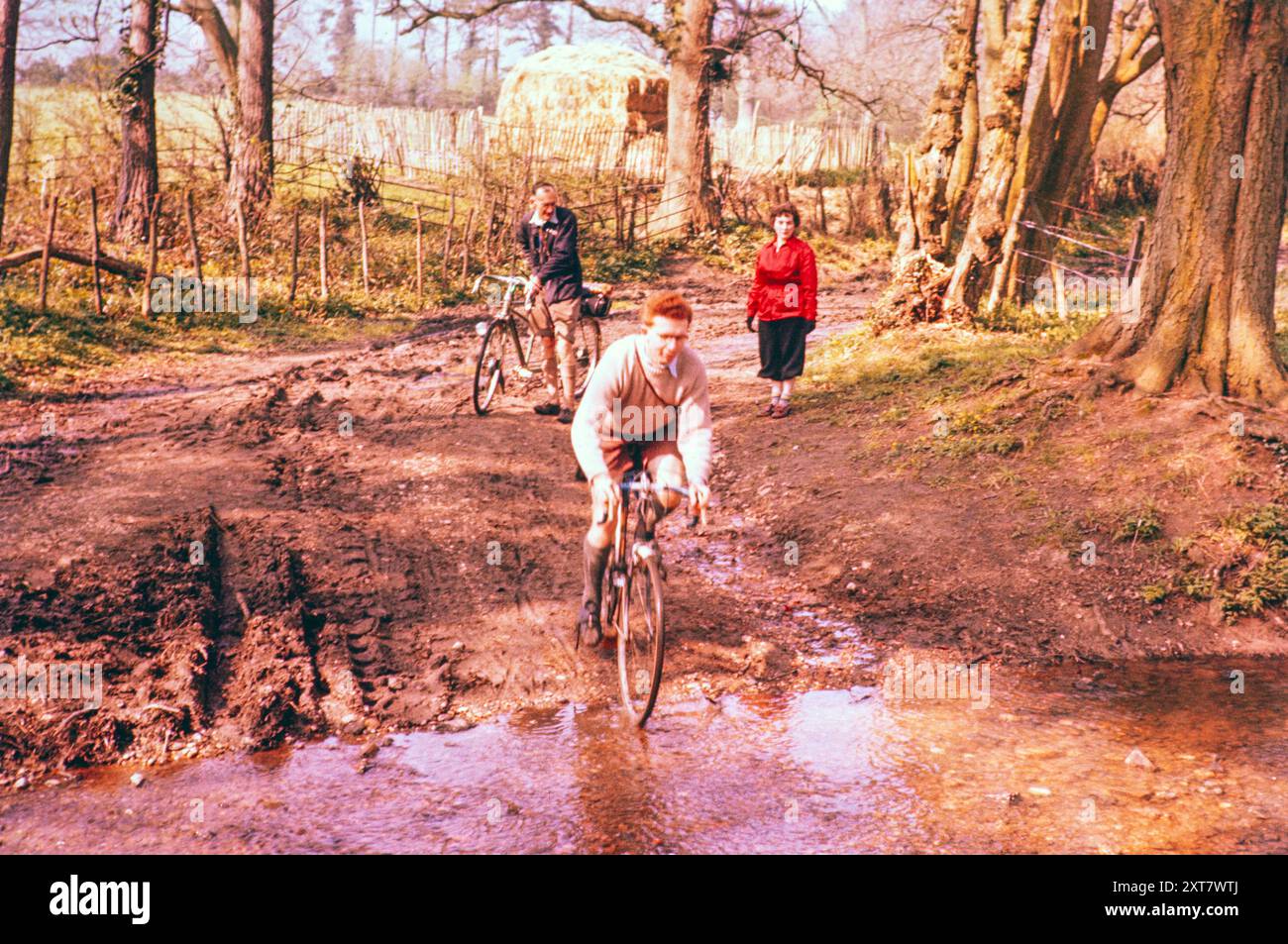 Cyclists negotiating cross country path crossing a stream, southern ...