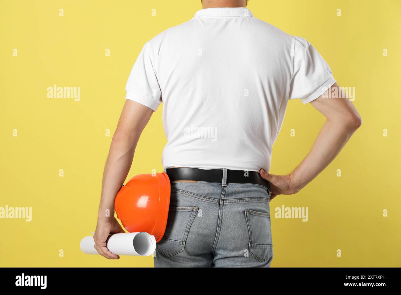 Engineer with hard hat and draft on yellow background, back view Stock ...