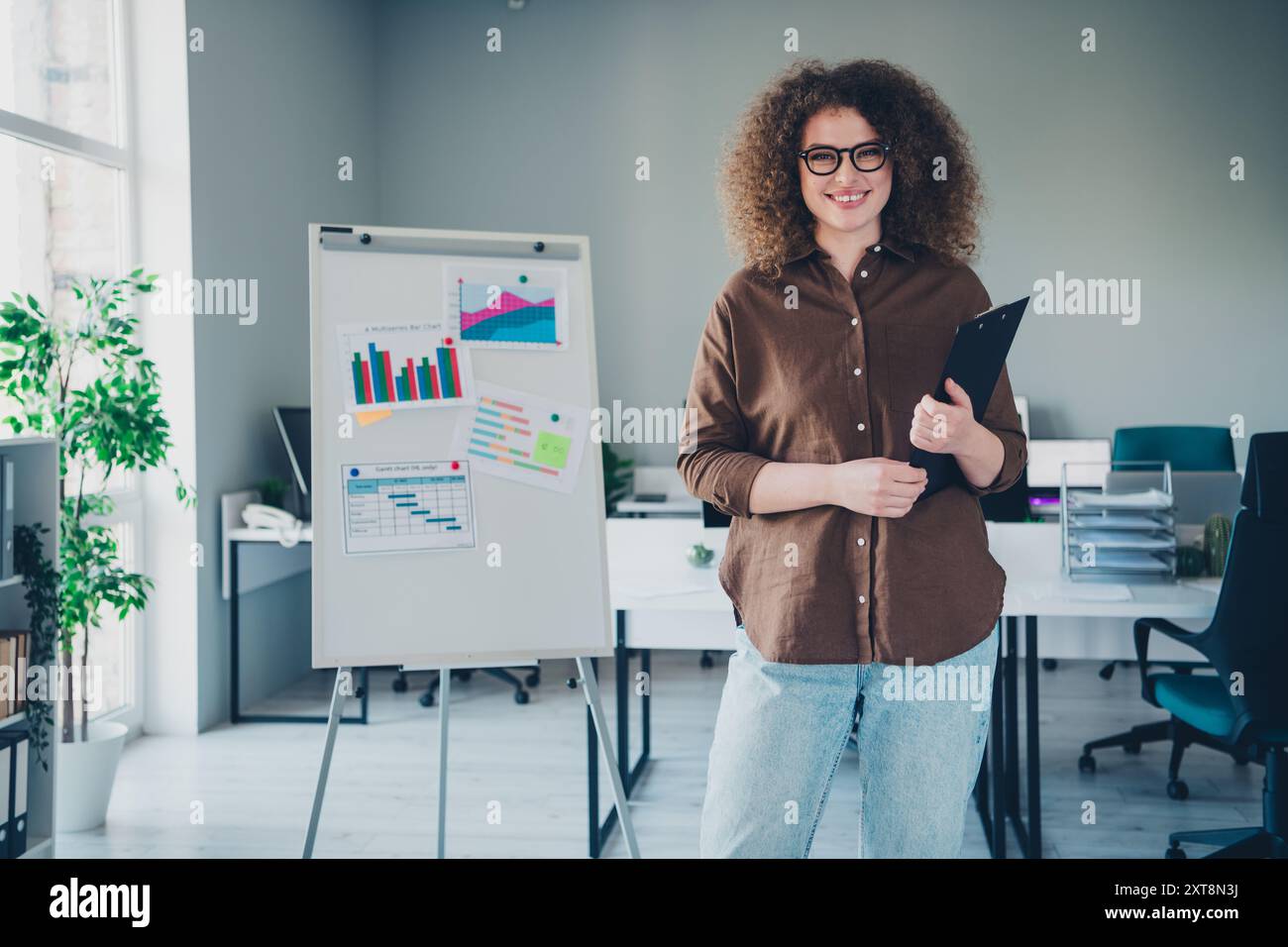 Photo of positive charming successful woman presenting board with stats ...