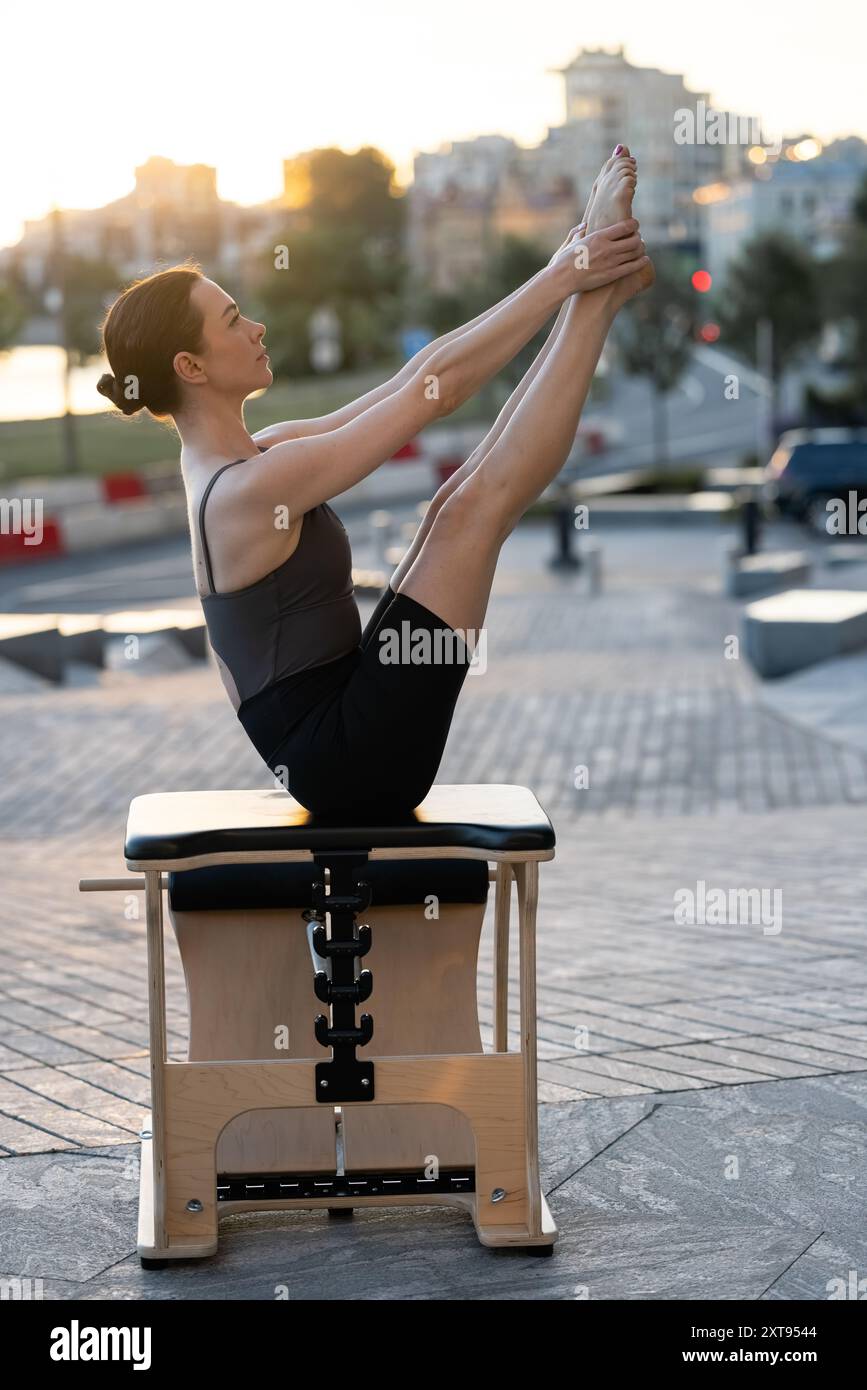 Pilates reformer chair woman fitness yoga gym exercise Stock Photo - Alamy